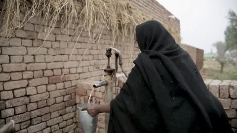 A lady from a Punjab village pumps water... | Stock Video | Pond5