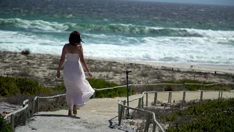 This lady is strolling down to the ocean... | Stock Video | Pond5