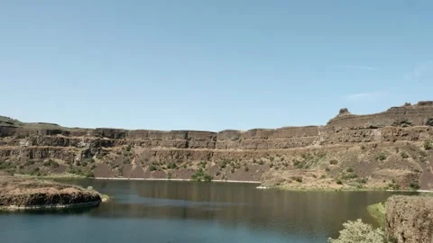 Lake at base of Dry Falls rock cliffs, f... | Stock Video | Pond5