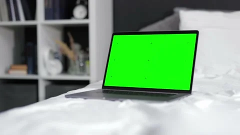 Laptop with green screen on bed | Stock Video | Pond5