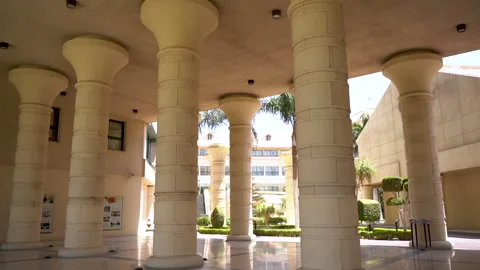 a large building with columns and palm t... | Stock Video | Pond5