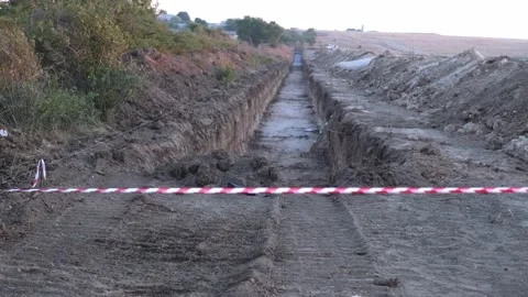 A large trench was dug in the ground. Pi... | Stock Video | Pond5