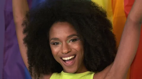 Laughing woman raising rainbow flag | Stock Video | Pond5