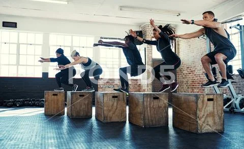Launch and landing. a focused group of young people jumping onto crates ...