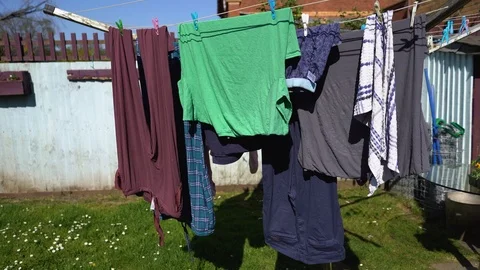 Laundry drying on clothes line with wood... | Stock Video | Pond5