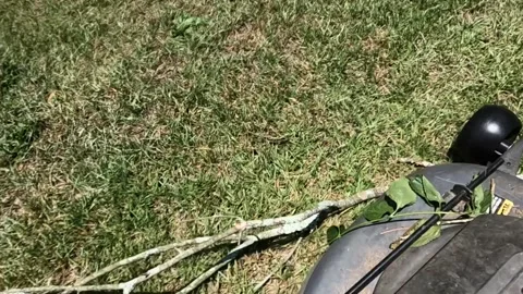 A lawn mower with a stick stuck under wh... | Stock Video | Pond5