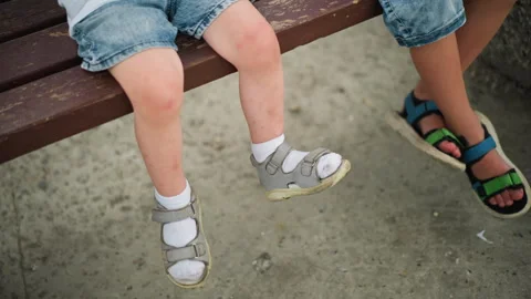 Leg View of Two Children Swinging Their ... | Stock Video | Pond5