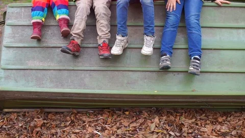 The legs of four seated children on the ... | Stock Video | Pond5