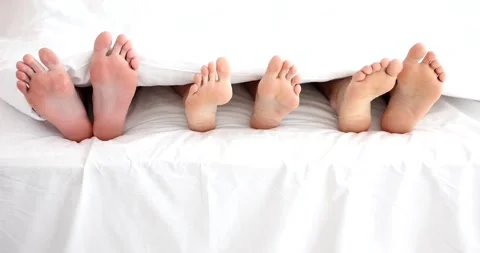 Legs of woman with two men in bed in bed... | Stock Video | Pond5