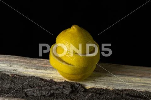 Photograph: Lemon on a dark background. Sliced lemon on a black ...