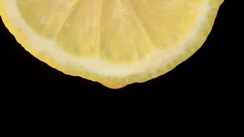 Lemon with dripping clear juice on black... | Stock Video | Pond5