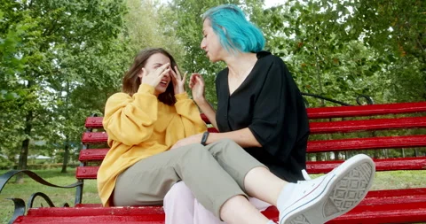 Lesbian couple chilling on bench in park | Stock Video | Pond5