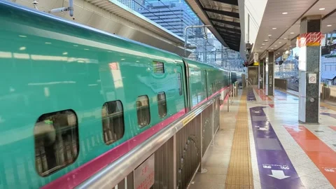 A light blue bullet train pulling into T... | Stock Video | Pond5
