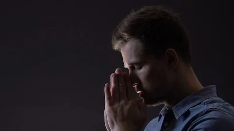 Light falling on man praying faithfully ... | Stock Video | Pond5