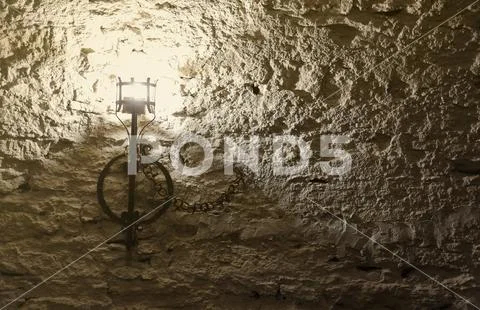 Lighted medieval castle torch hanging on a stone wall, vintage objects ...