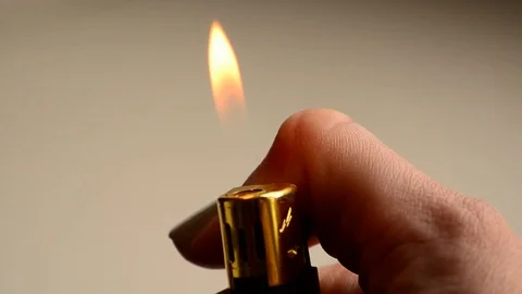 Lighter finger burning fire on light bac... | Stock Video | Pond5
