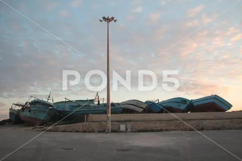 Line row of small wrecked boats ships shipwreck on shore leaning ...