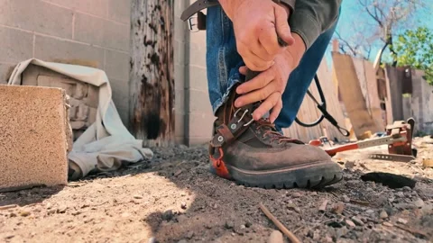 Lineman strapping on his boot spike atta... | Stock Video | Pond5