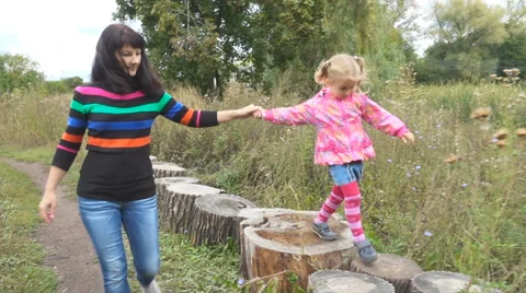 Little baby girl walking on the stumps w... | Stock Video | Pond5
