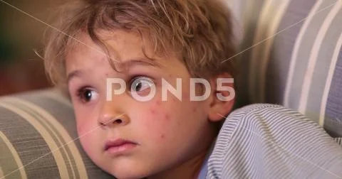 Photograph: Little boy child watching TV at night. Face of kid staring ...