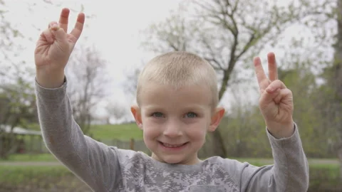 Little Boy Gives Peace Signs | Stock Video | Pond5