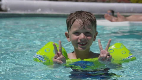 Little Boy Giving Peace Signs In Pool | Stock Video | Pond5