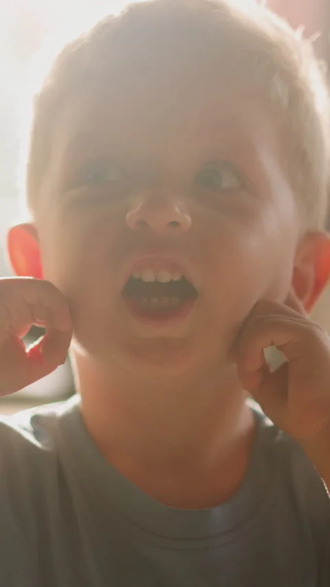 Little boy with open mouth closes ears b... | Stock Video | Pond5