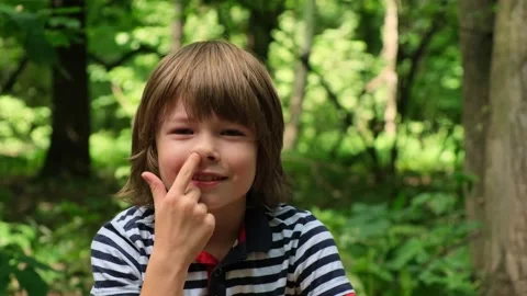 Little boy picks boogers in his nose | Stock Video | Pond5