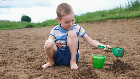 Little boy is playing digging a pit with... | Stock Video | Pond5