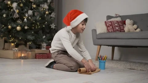 Little boy in red hat rolling letter | Stock Video | Pond5