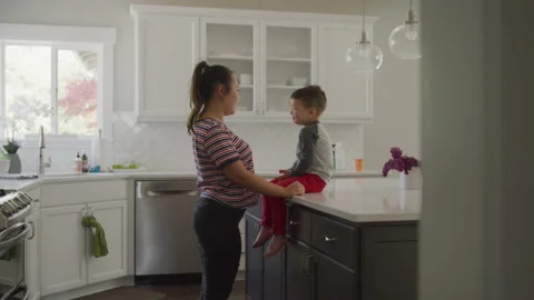 Little Boy Sitting on Kitchen Counter Gi... | Stock Video | Pond5