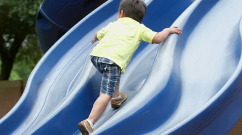little boy on a slide in a park | Stock Video | Pond5