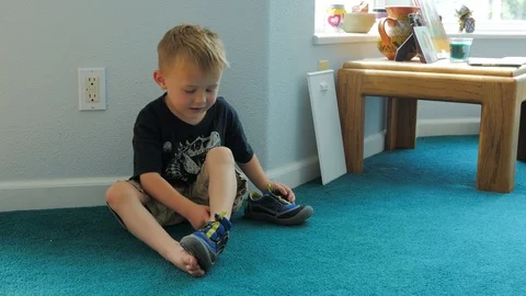 Little boy slips on his shoes inside the... | Stock Video | Pond5