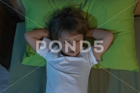 Little boy snoring while sleeping in bed at night, top view Stock Photo ...