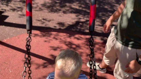 A little boy swings on a swing on the pl... | Stock Video | Pond5
