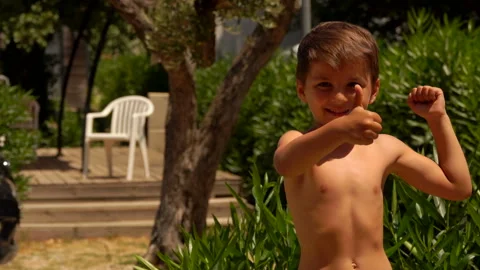 The little cheerful tanned boy is showin... | Stock Video | Pond5