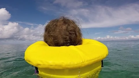 Little child floating with a life jacket... | Stock Video | Pond5
