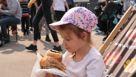 Little child girl eating sweet pastry on... | Stock Video | Pond5