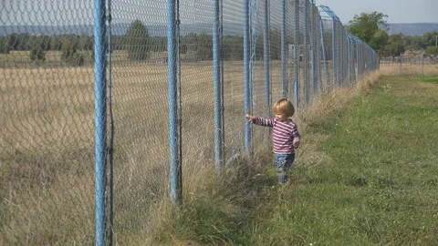 Little child push a big fence, toddler b... | Stock Video | Pond5