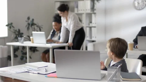 Little Child Sitting at Office Desk whil... | Stock Video | Pond5