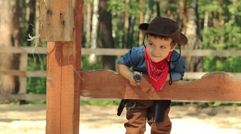 Little cowboy with toy gun sitting on a ... | Stock Video | Pond5