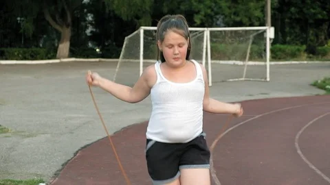 Little fat girl jumping rope in the stad... | Stock Video | Pond5