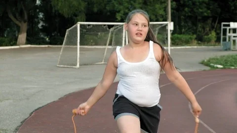 Little fat girl jumping rope in the stad... | Stock Video | Pond5