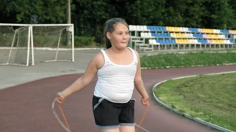 Little fat girl jumping rope in the stad... | Stock Video | Pond5
