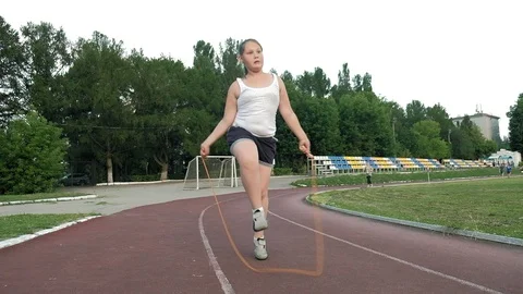 Little fat girl jumping rope in the stad... | Stock Video | Pond5