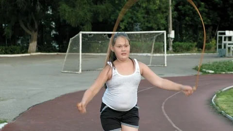 Little fat girl jumping rope in the stad... | Stock Video | Pond5