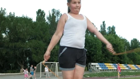 Little fat girl jumping rope in the stad... | Stock Video | Pond5