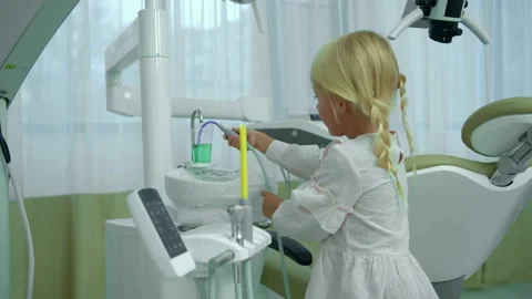Little girl checks saliva ejector in cab... | Stock Video | Pond5