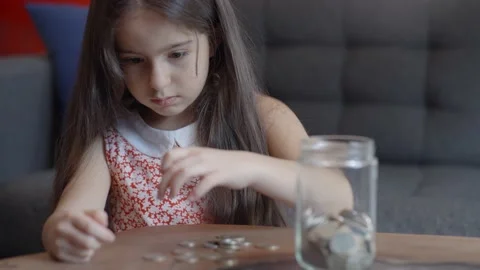The little girl is counting the coins sh... | Stock Video | Pond5