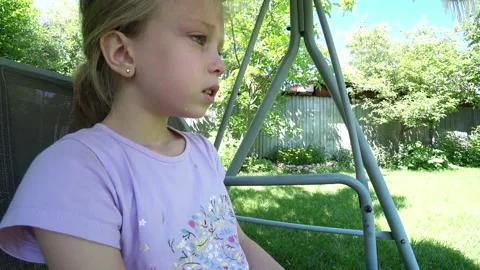little girl crying on the garden bench | Stock Video | Pond5